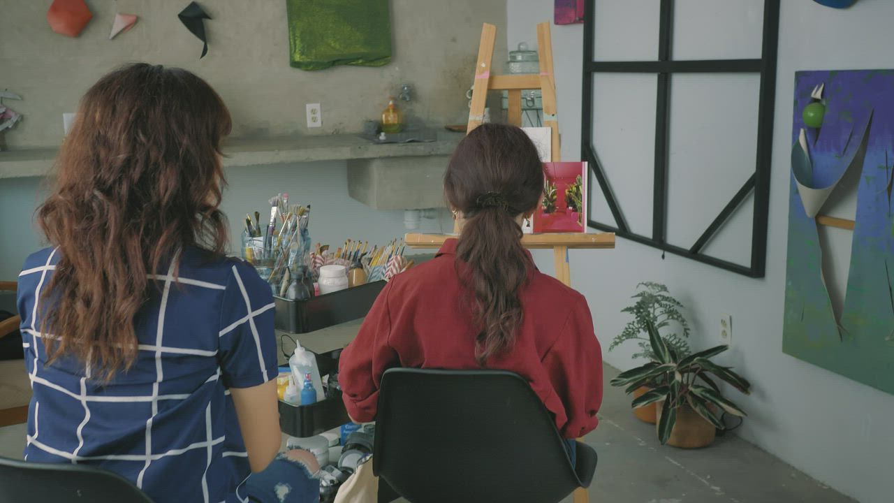 Pair of artist girls working together on a painting - Free Stock Video
