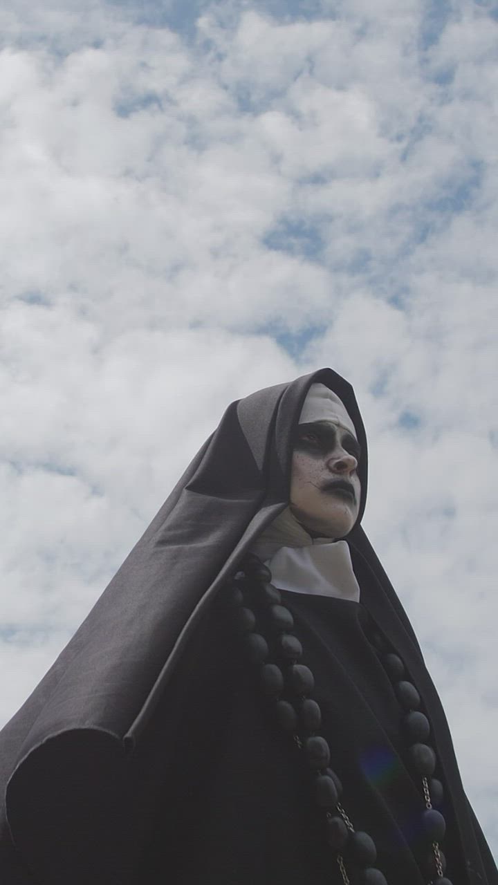 Portrait of a devilish nun smiling - Free Stock Video