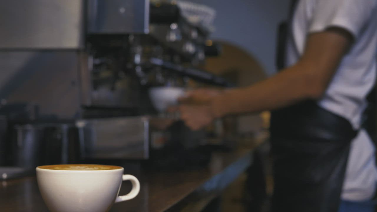 Employee serving a cup of coffee from a machine - Free Stock Video