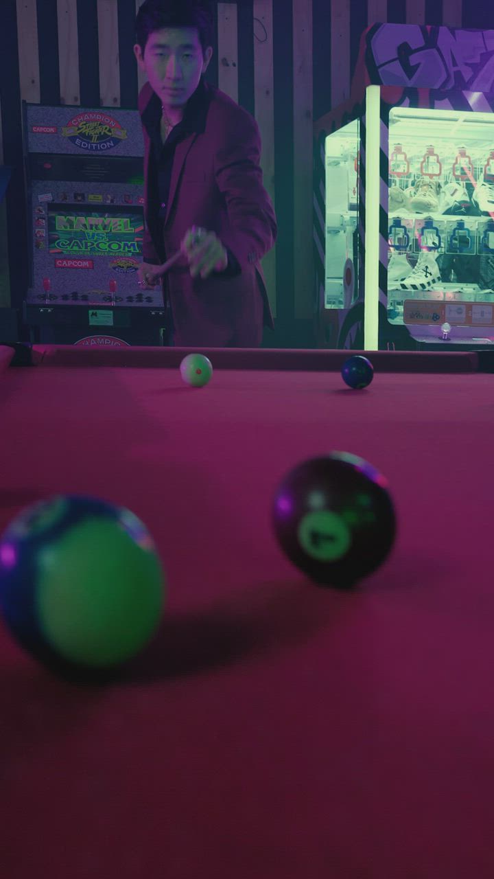 Young gangster playing billiards in a dark arcade - Free Stock Video