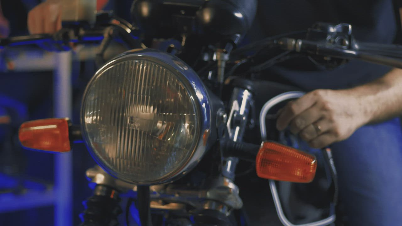 Headlight of a motorcycle that is turned on by a person - Free Stock Video