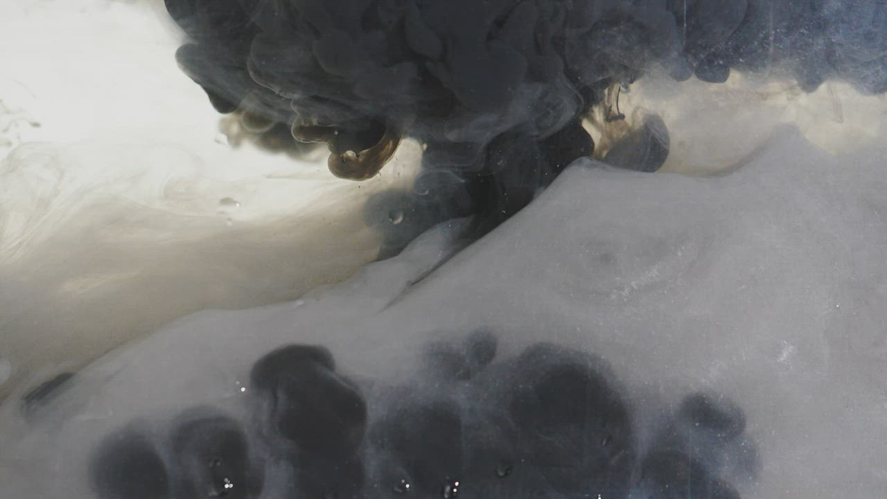 Cloud of black and white ink slowly moving in water - Free Stock Video