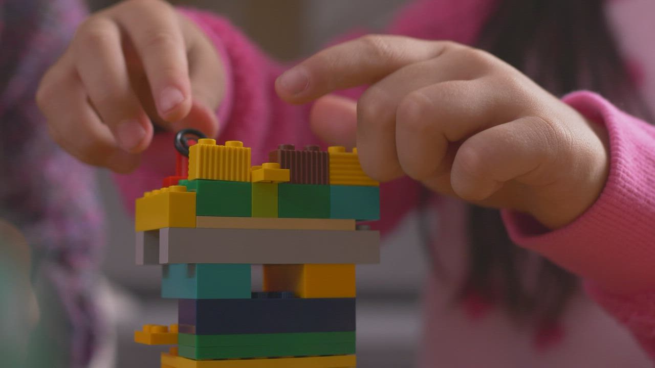 Girl putting together a figure with legos - Free Stock Video