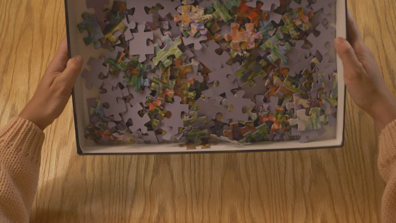 Emptying a box with puzzle pieces - Free Stock Video