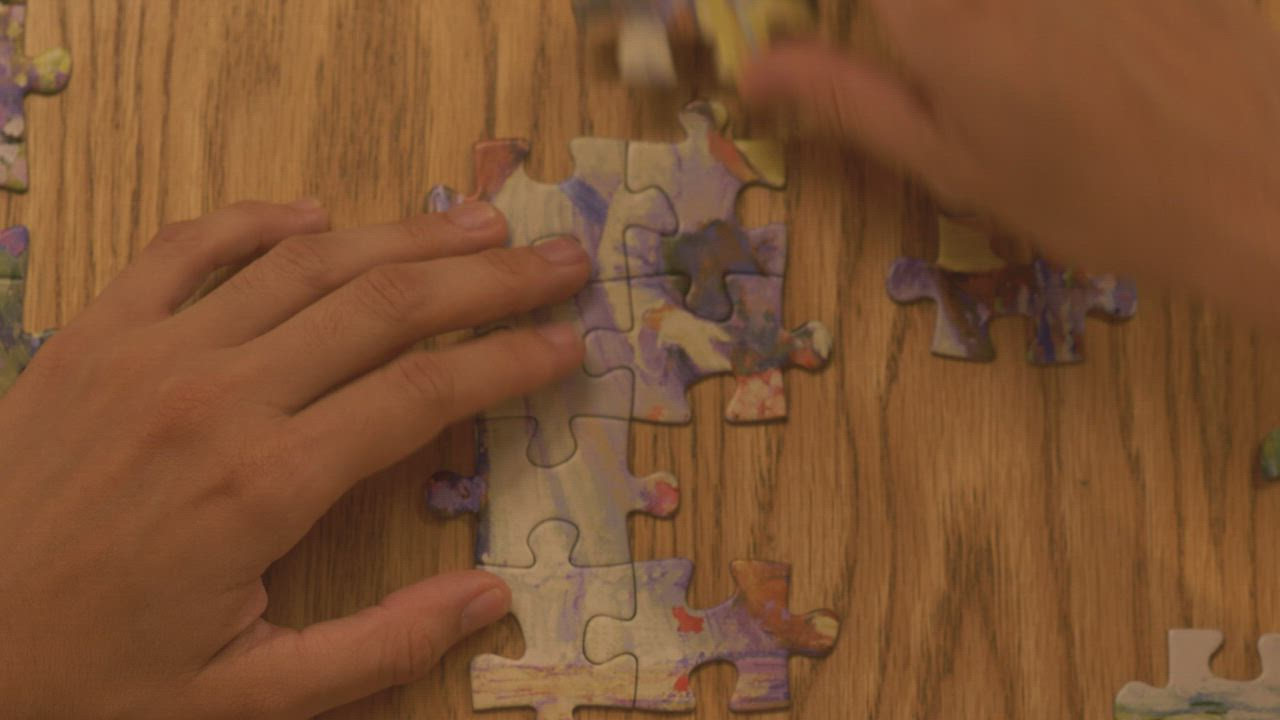 Person building a puzzle on a table - Free Stock Video