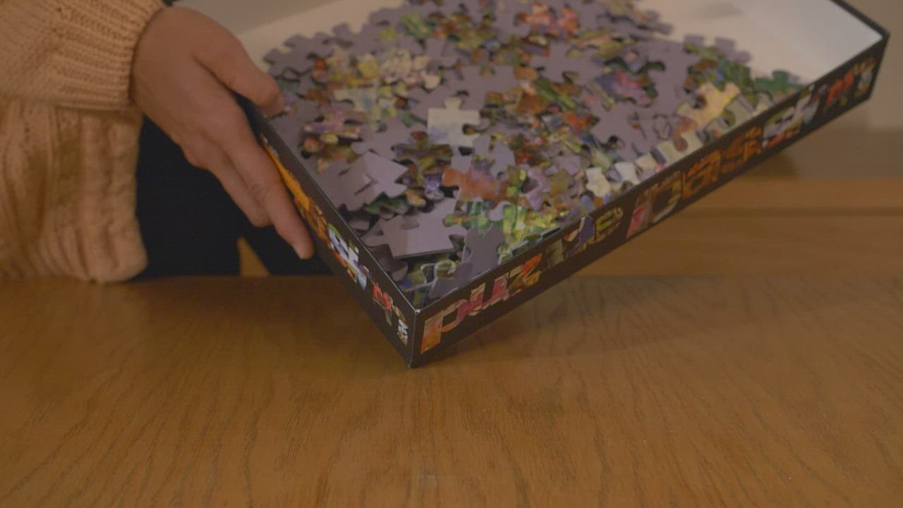 Throwing puzzle pieces out of a box - Free Stock Video