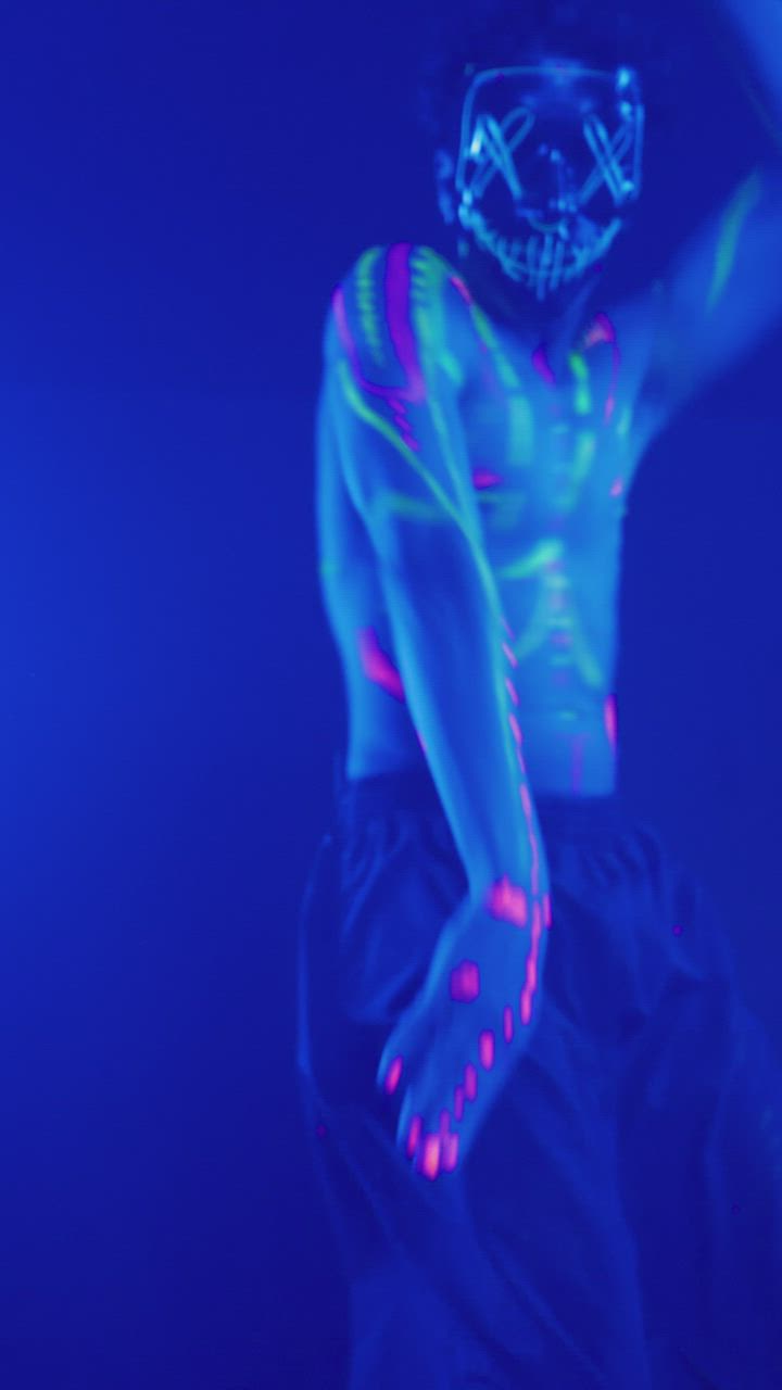 Man with neon mask dancing with party light - Free Stock Video