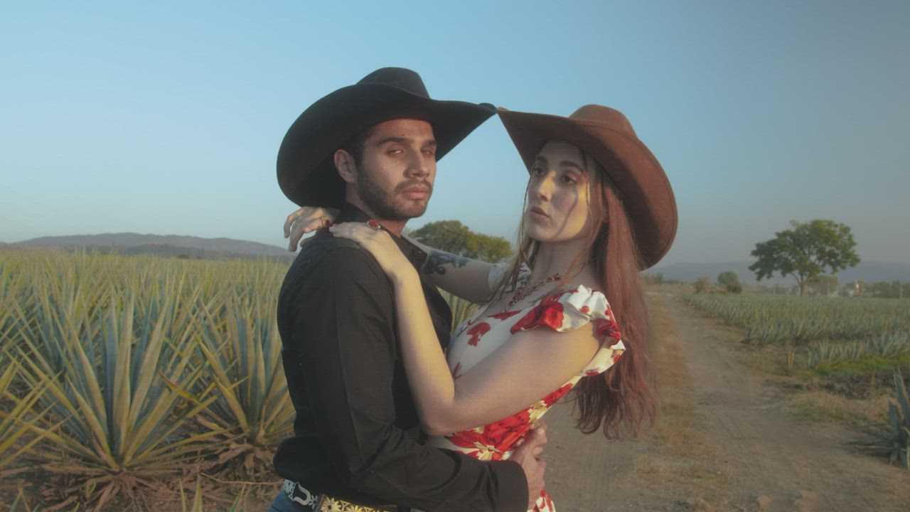 Romantic couple with Mexican style in a sunny field - Free Stock Video