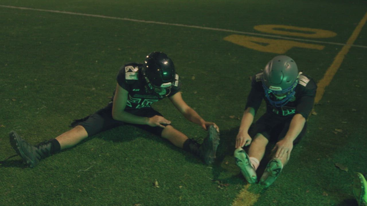Football team stretching on a field - Free Stock Video