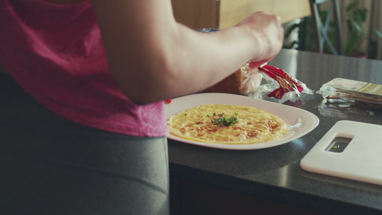 Young woman finishing preparing her breakfast - Free Stock Video