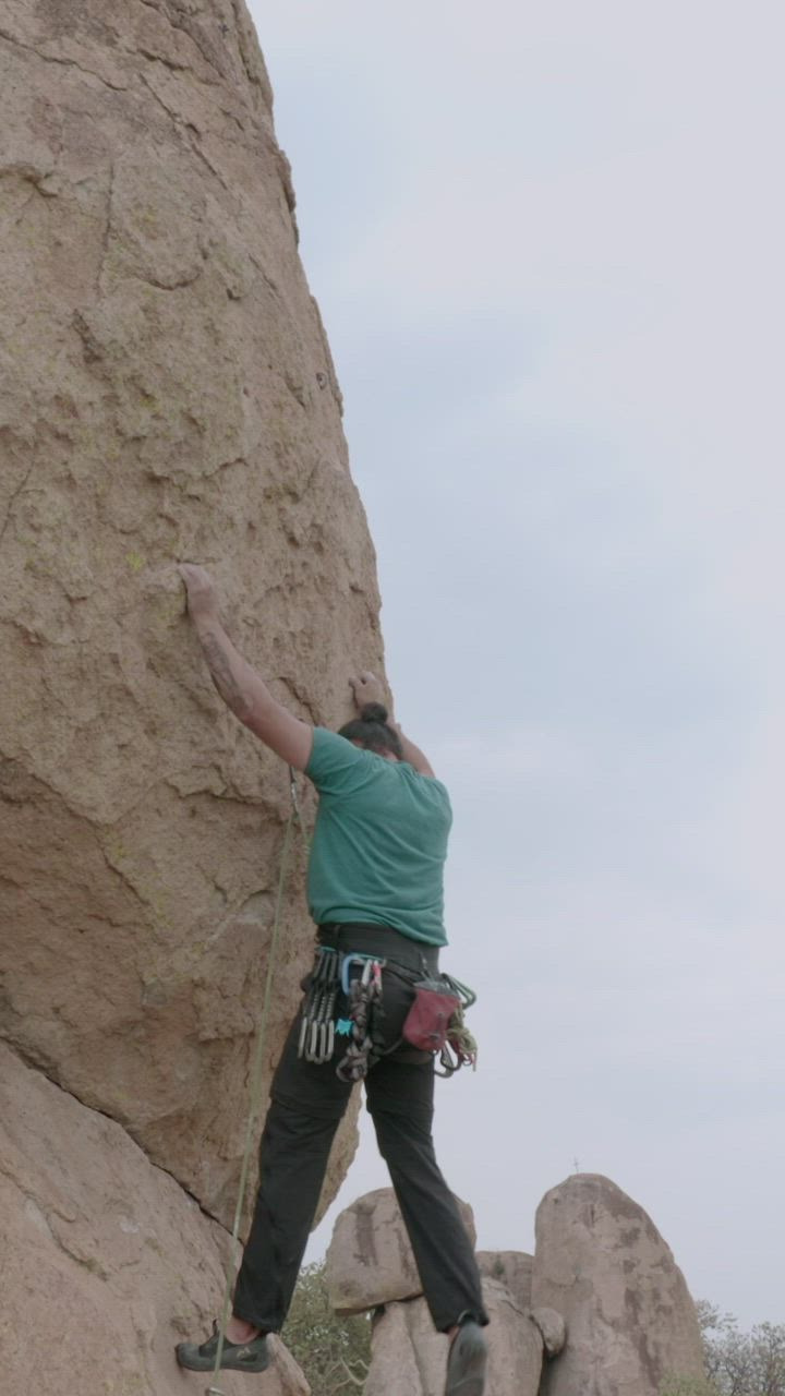 Mountain climber climbing a vertical rock face - Free Stock Video