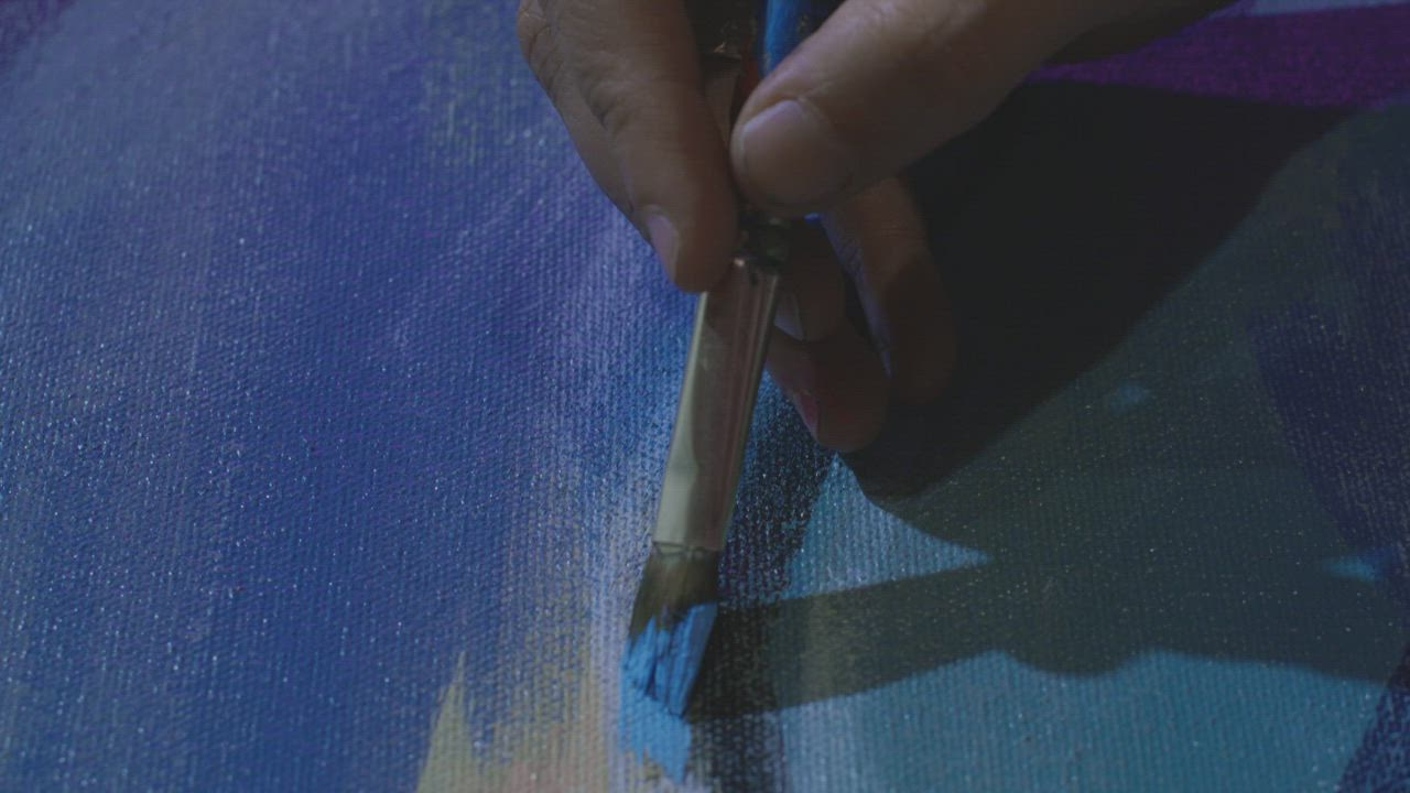 Artist brushing paint across a canvas - Free Stock Video