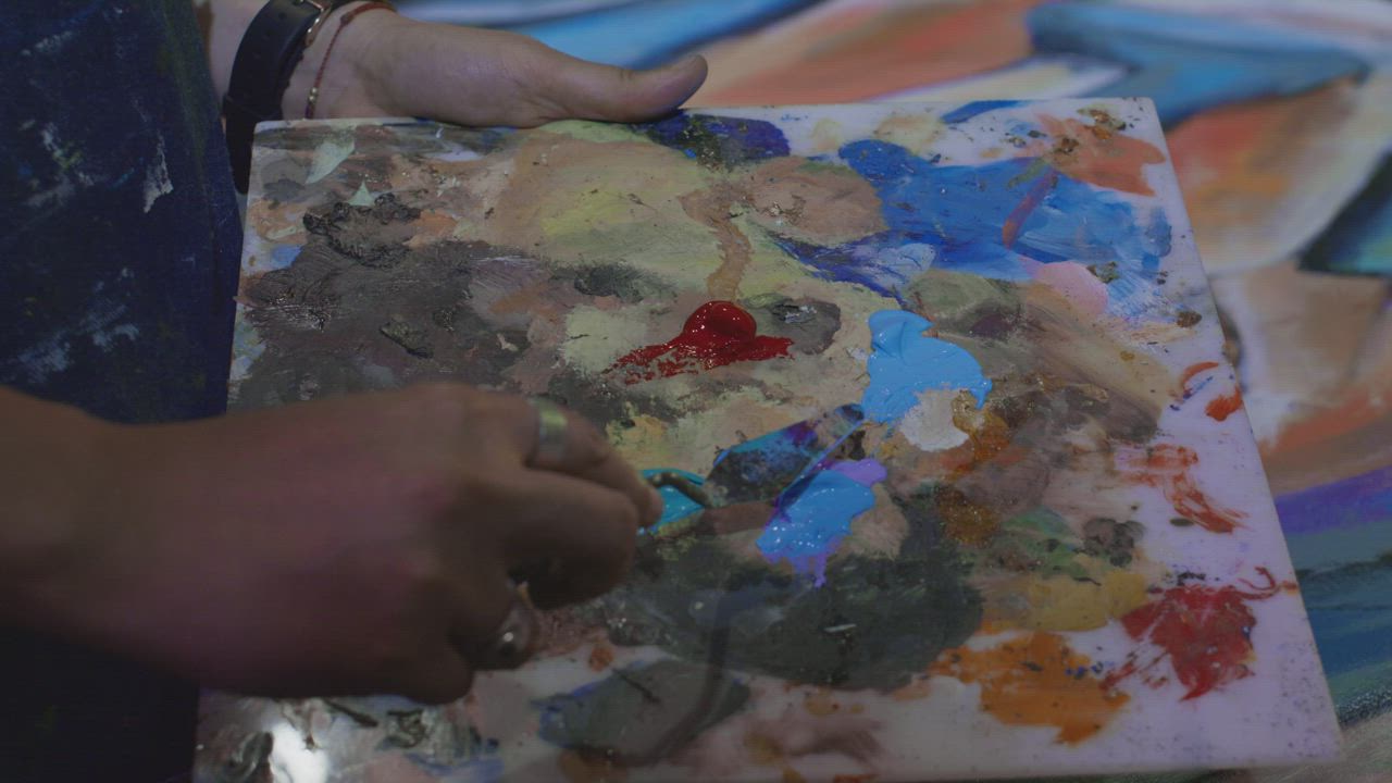 Artist mixing paint on her palette - Free Stock Video