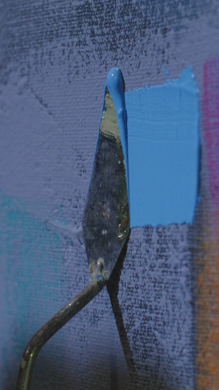 Artist applying paint to a painting with a palette - Free Stock Video