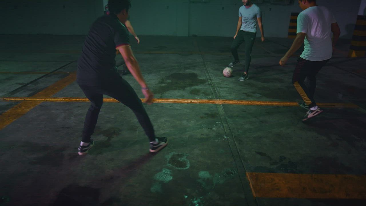 Guys playing football in a parking lot - Free Stock Video
