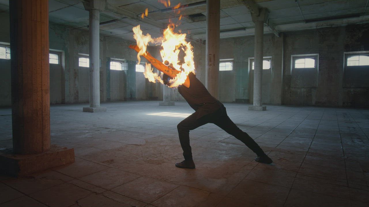 Expert juggler doing tricks with a stick with fire - Free Stock Video