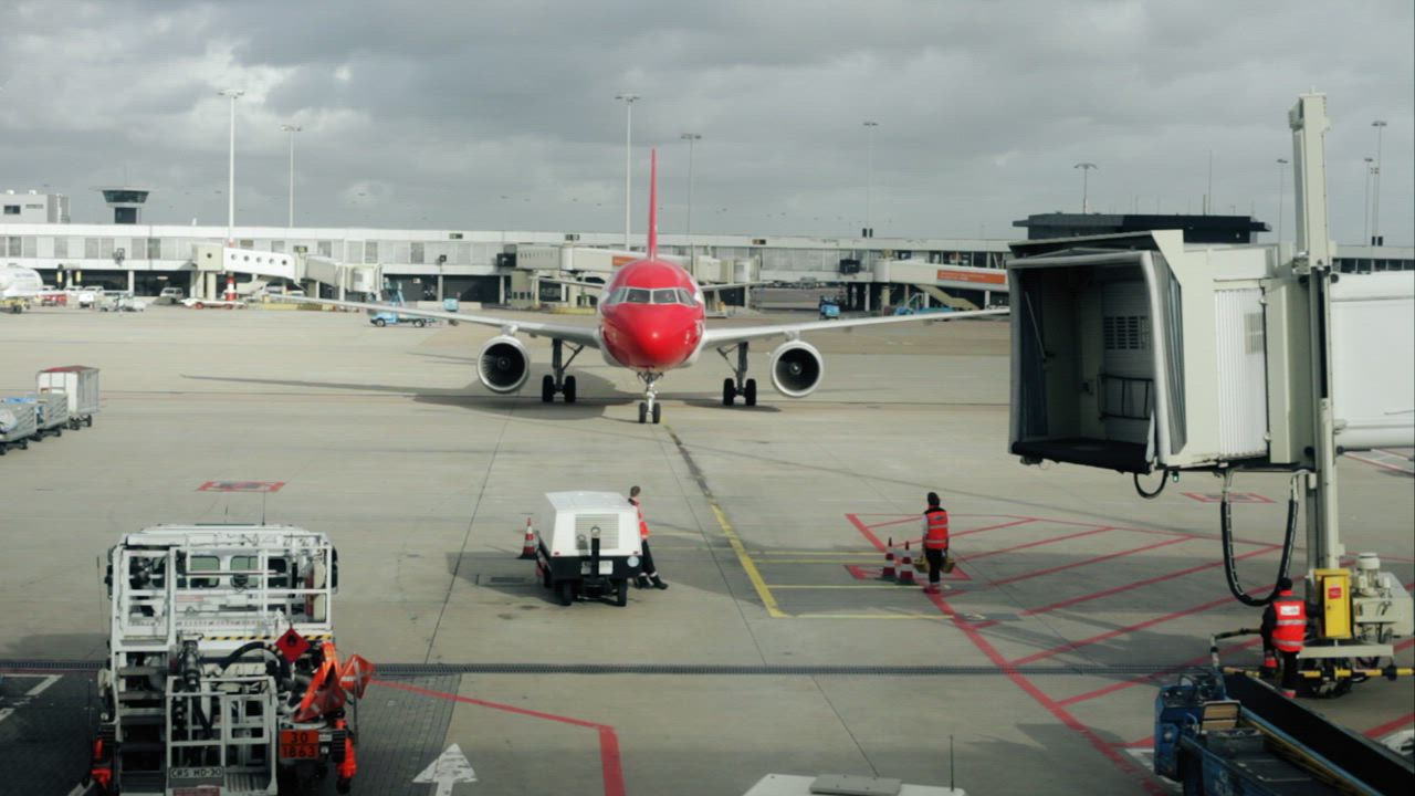 Plane arriving to an airport terminal - Free Stock Video
