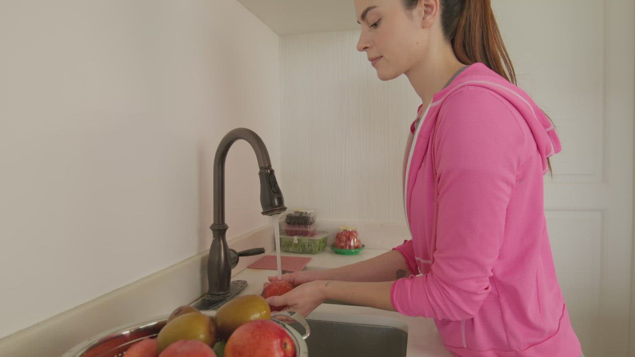Young woman washing fruit in her kitchen - Free Stock Video