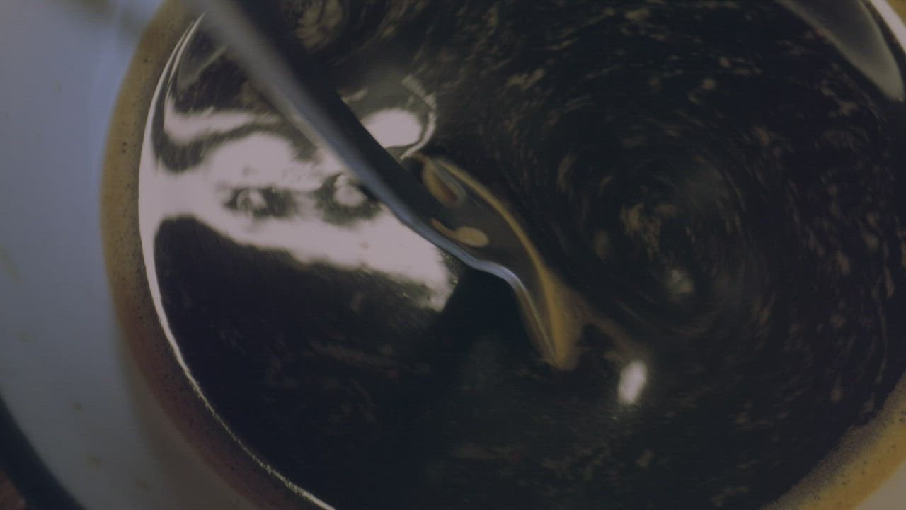 Mixing coffee in a cup seen up close - Free Stock Video