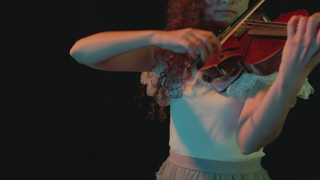 Skillful violinist playing on a dark background - Free Stock Video