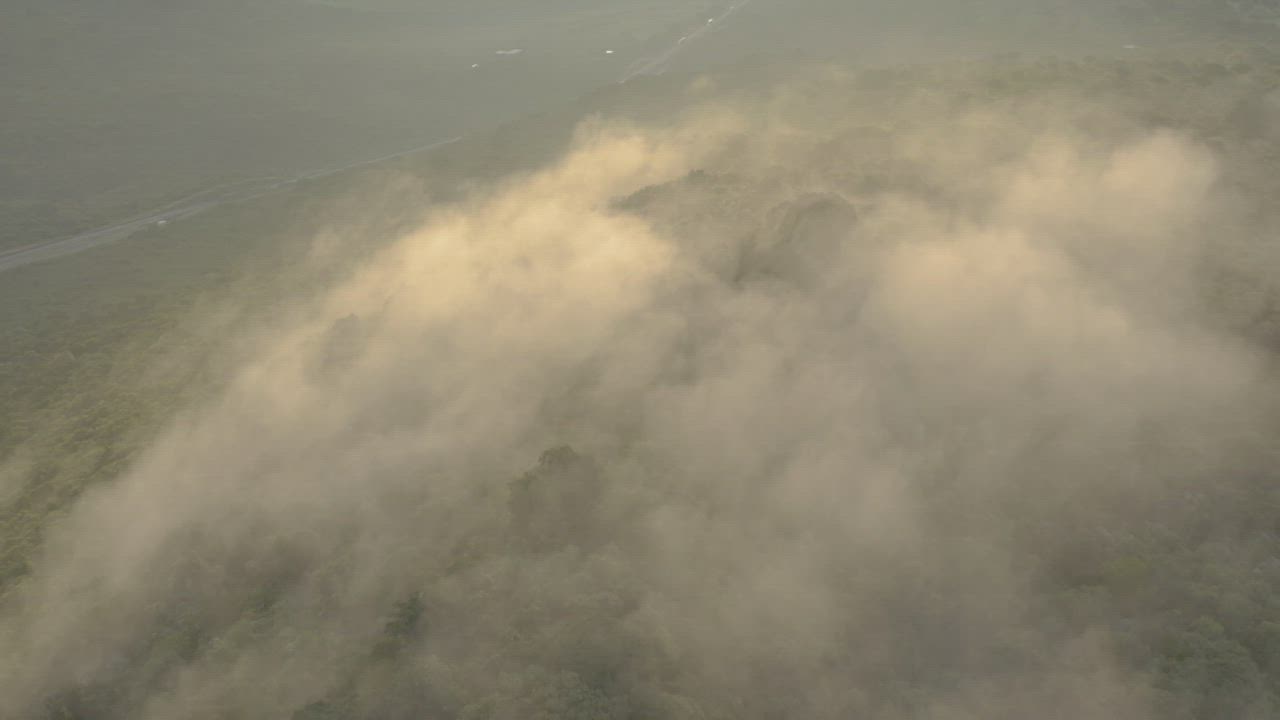 Fog covered hill in an aerial shot - Free Stock Video