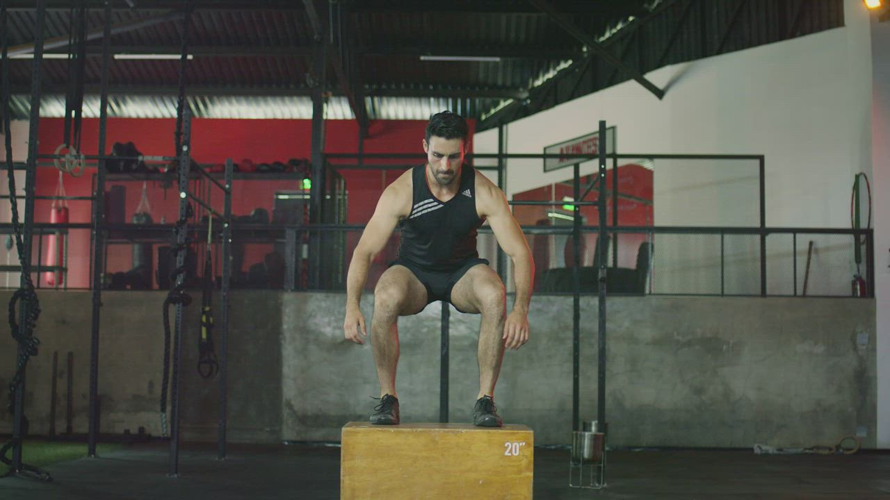 Man exercising by jumping onto a platform in a gym - Free Stock Video