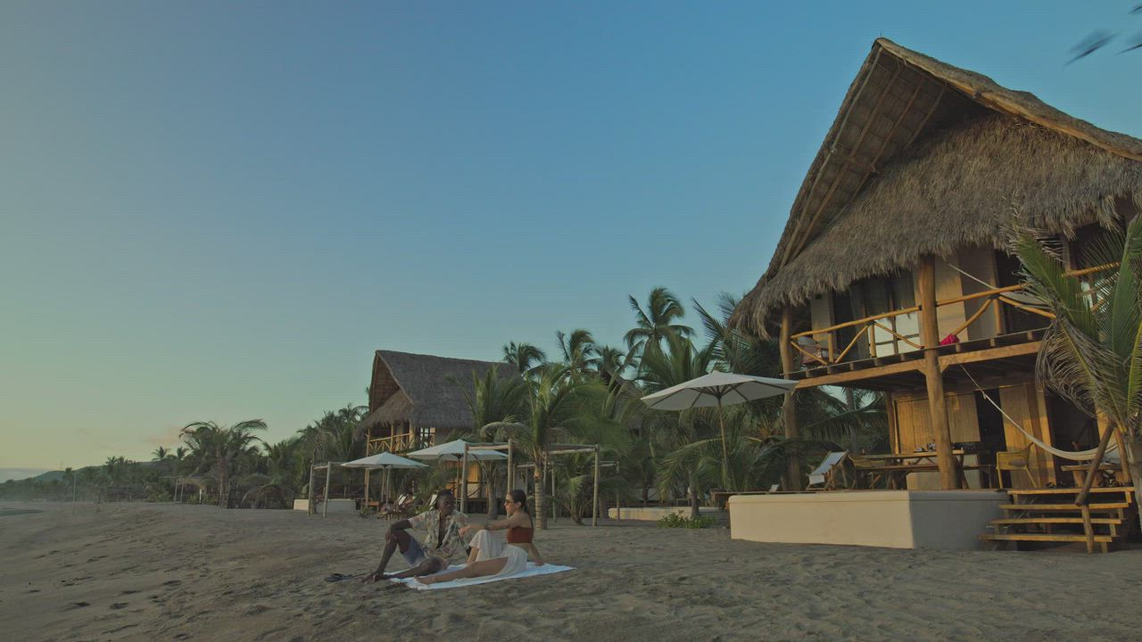 Couple watching the sunset on a beach - Free Stock Video