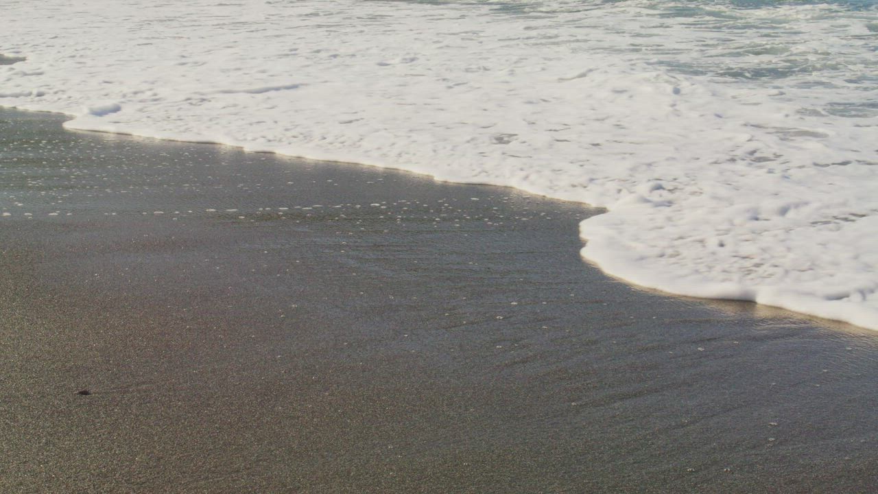 Texture of the waves covering the sand of a beach - Free Stock Video