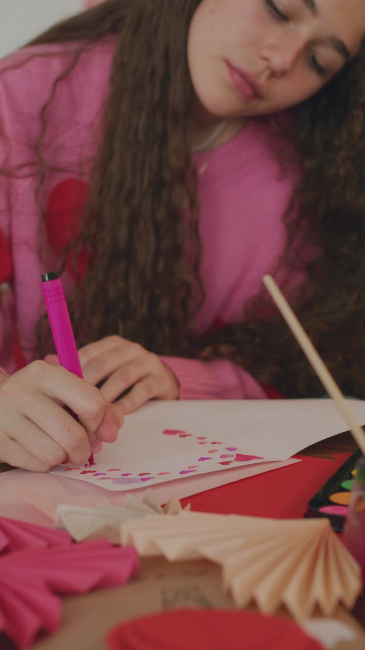 Portrait of a girl making a card for Valentine's Day - Free Stock Video