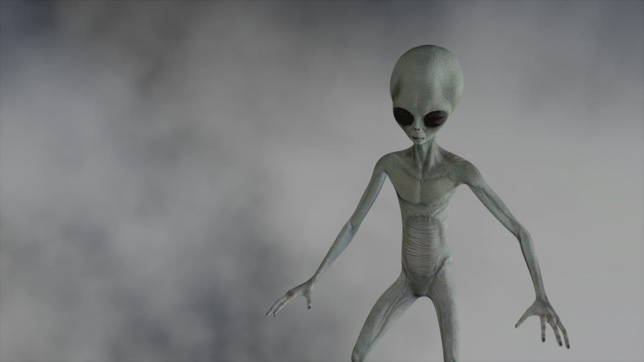 Grey alien with large black eyes standing on a smoking background ...