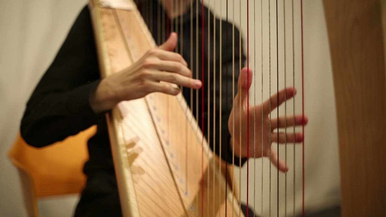 Musician strums the strings on the harp - Free Stock Video