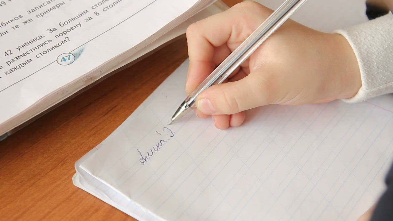 Student hand writes notes in a notebook - Free Stock Video