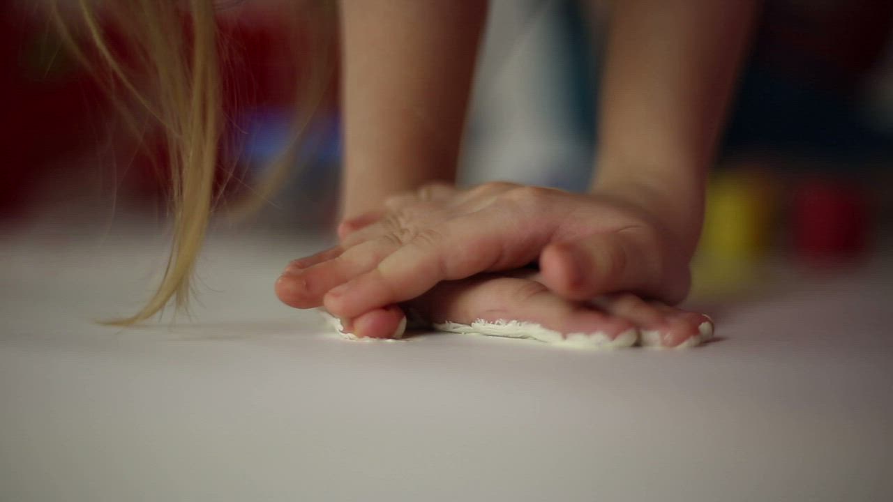 Child pressing paint handprints onto paper - Free Stock Video
