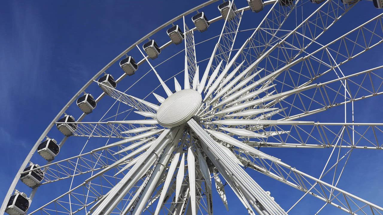 Large Ferris Wheel spinning slowly on a sunny day - Free Stock Video