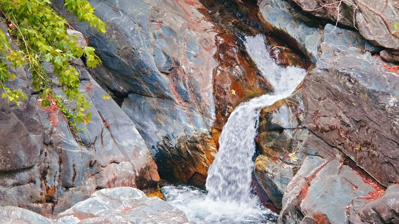 Water streaming off rocks as a waterfall - Free Stock Video