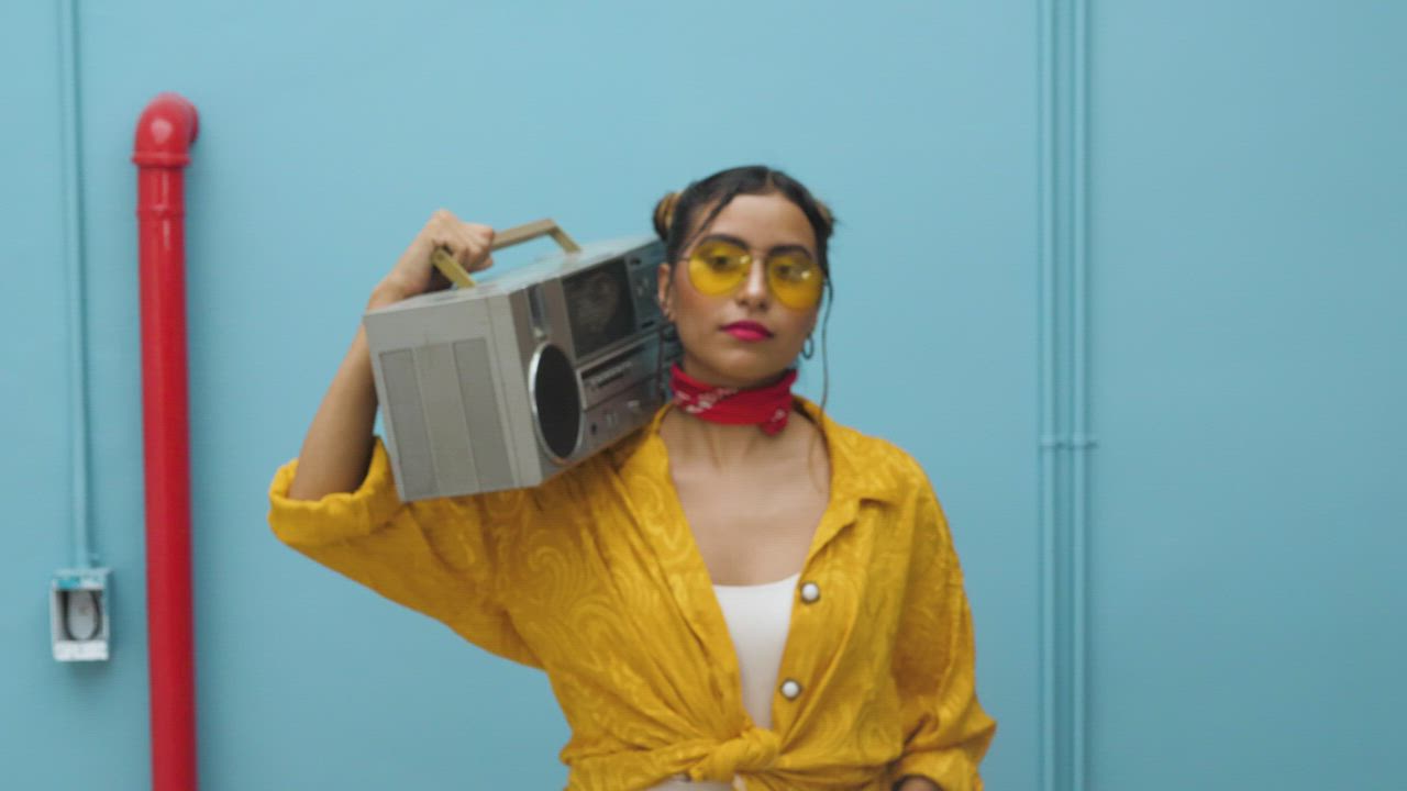 Woman carrying a retro boombox on her shoulder - Free Stock Video