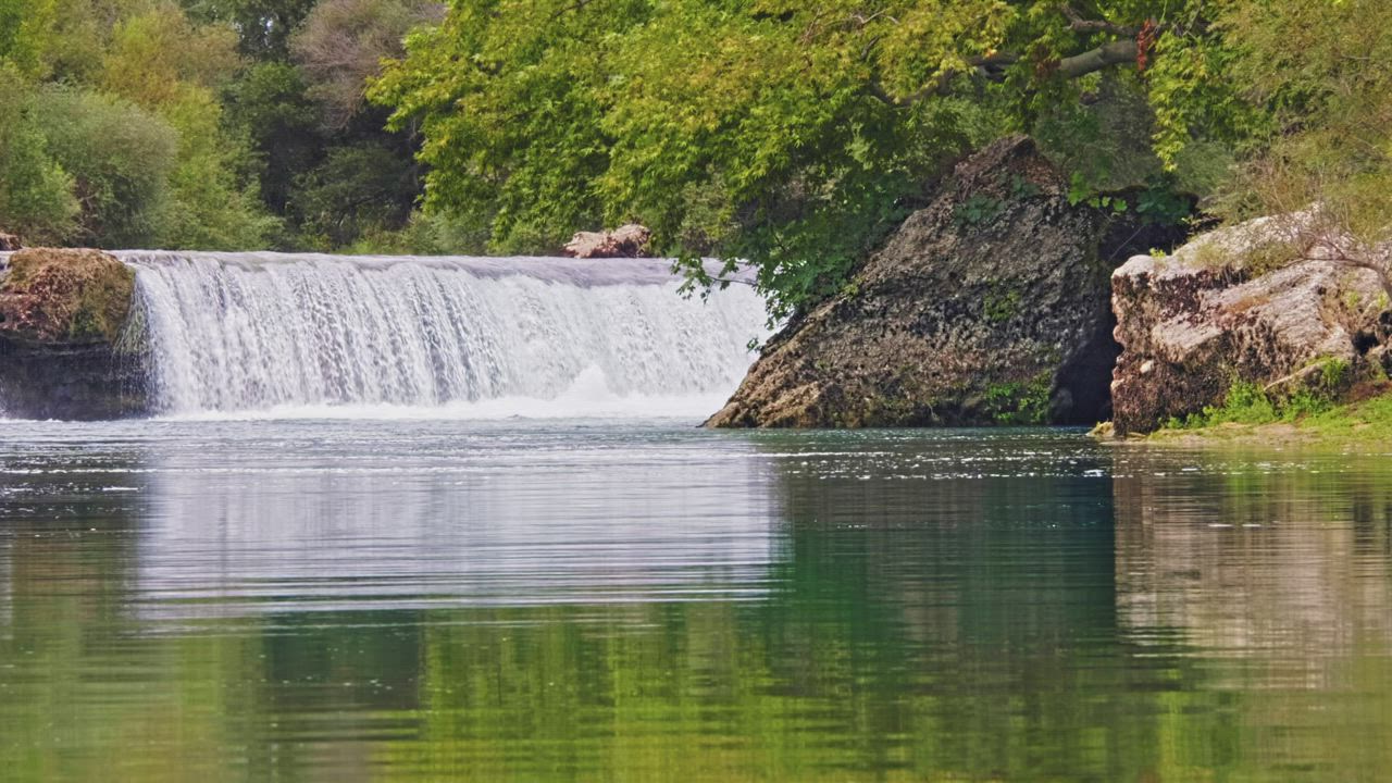 Water cascading into a river - Free Stock Video