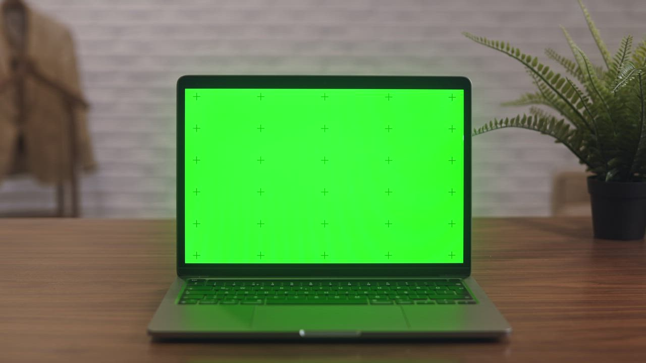 Laptop on a table with a green screen - Free Stock Video