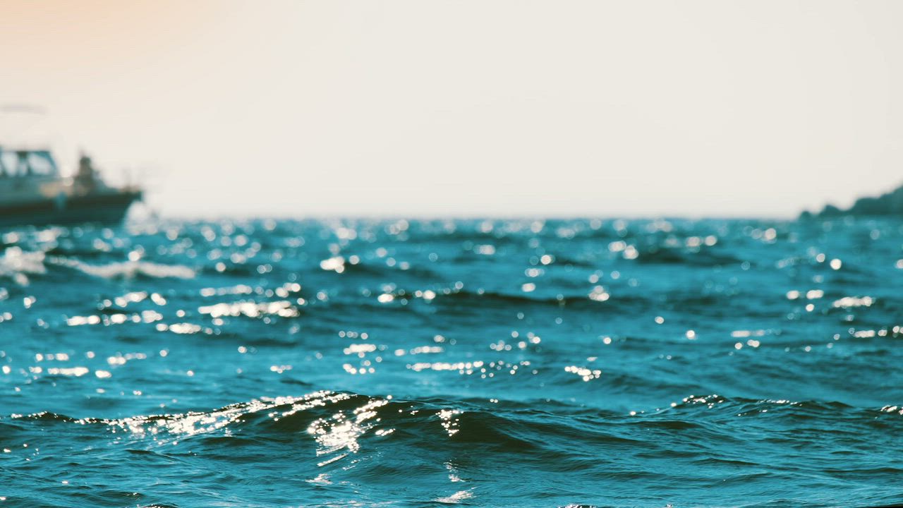 Ocean with a boat in the background - Free Stock Video