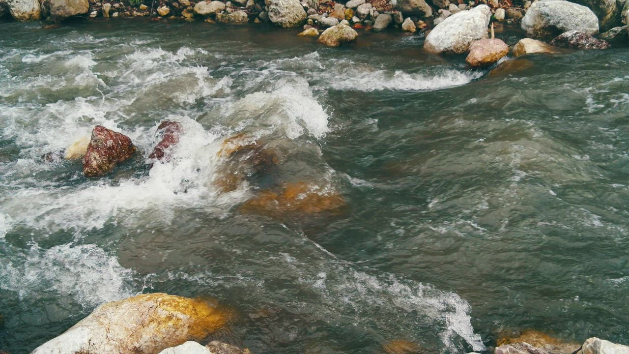 Water stream flowing over rocks - Free Stock Video