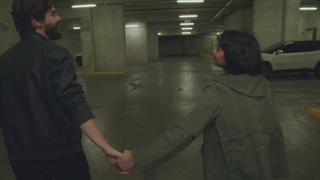 Loving couple playing through a parking lot - Free Stock Video