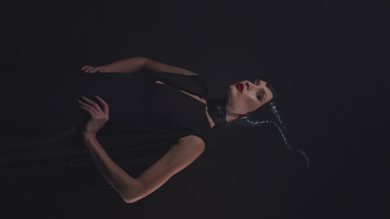 Menacing witch poses in front of a black background - Free Stock Video