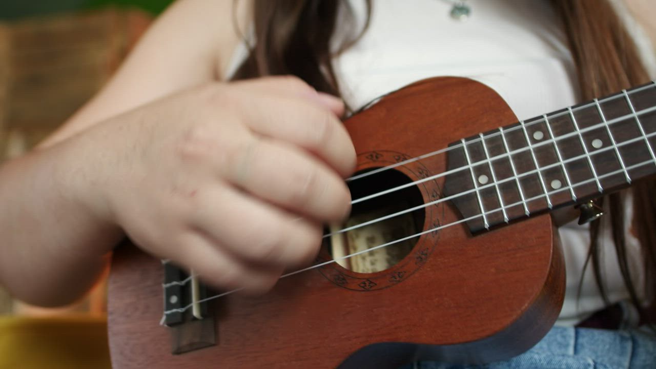 Girl lightly strumming a ukulele - Free Stock Video