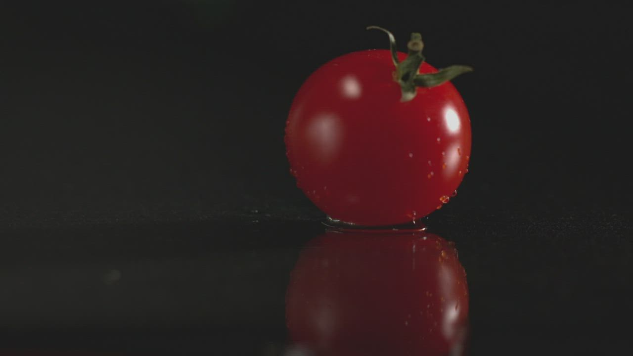 Small, juicy cherry tomato bouncing against a dark surface - Free Stock ...