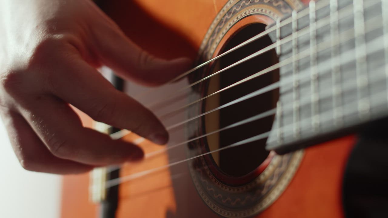 Close up of a musician expertly strumming the strings of a guitar ...