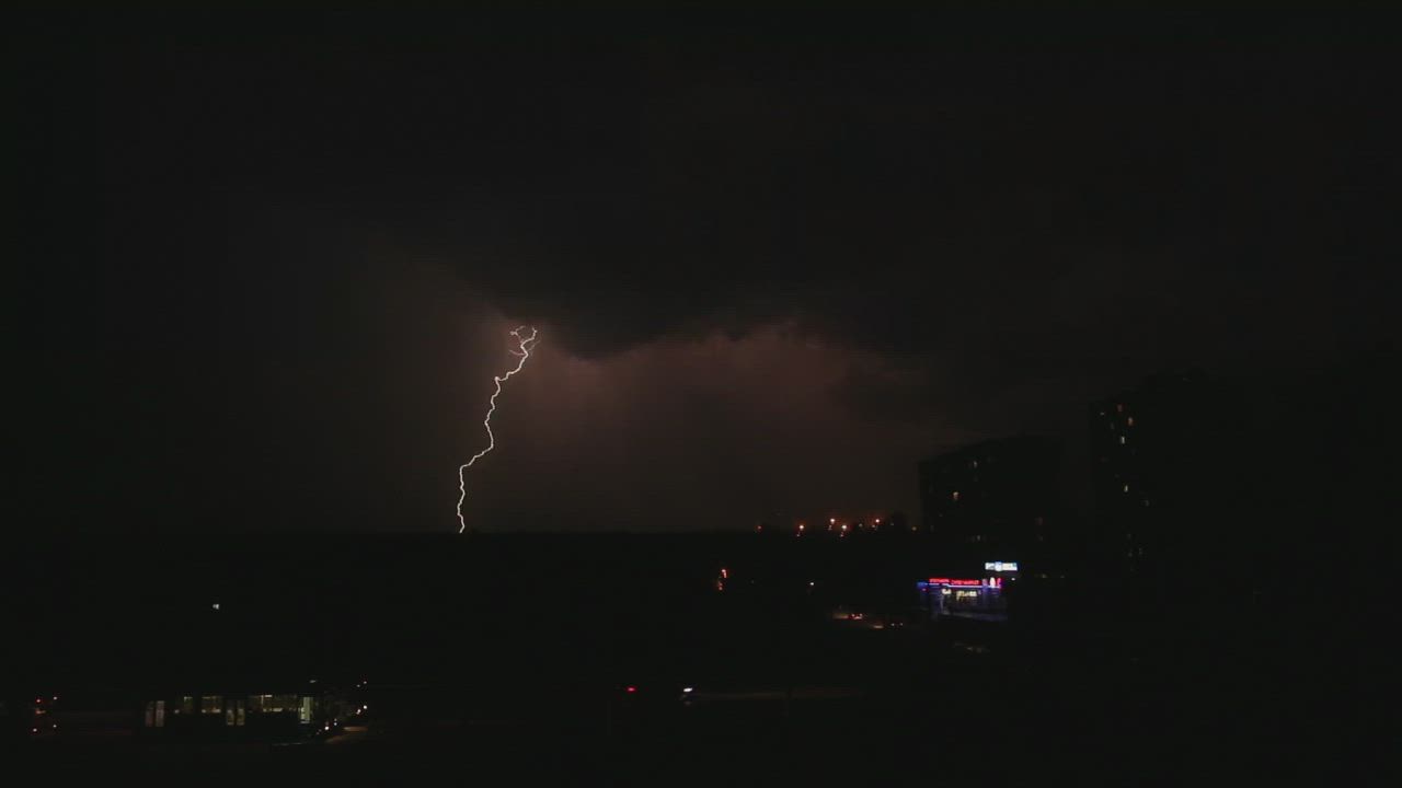 Lightning strikes over a city at midnight - Free Stock Video