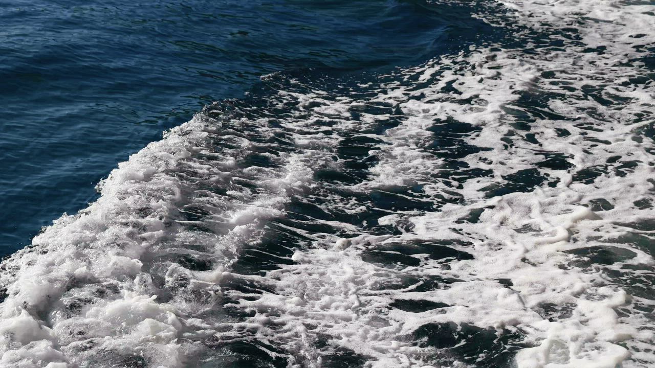 View off the back of a boat of the water breaking - Free Stock Video