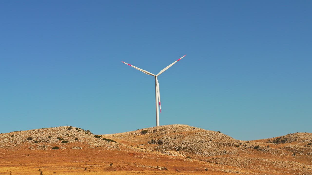 Wind turbine spinning on a sunny day - Free Stock Video