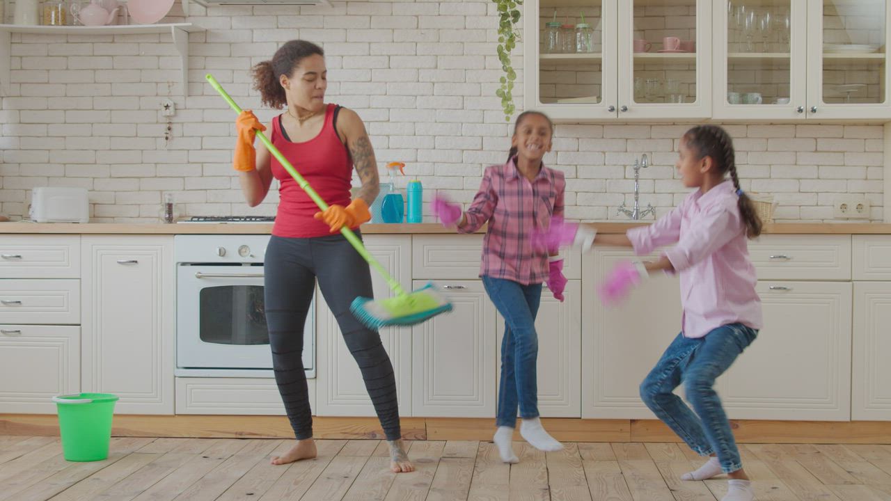 Mother and daughters in a kitchen dancing - Free Stock Video