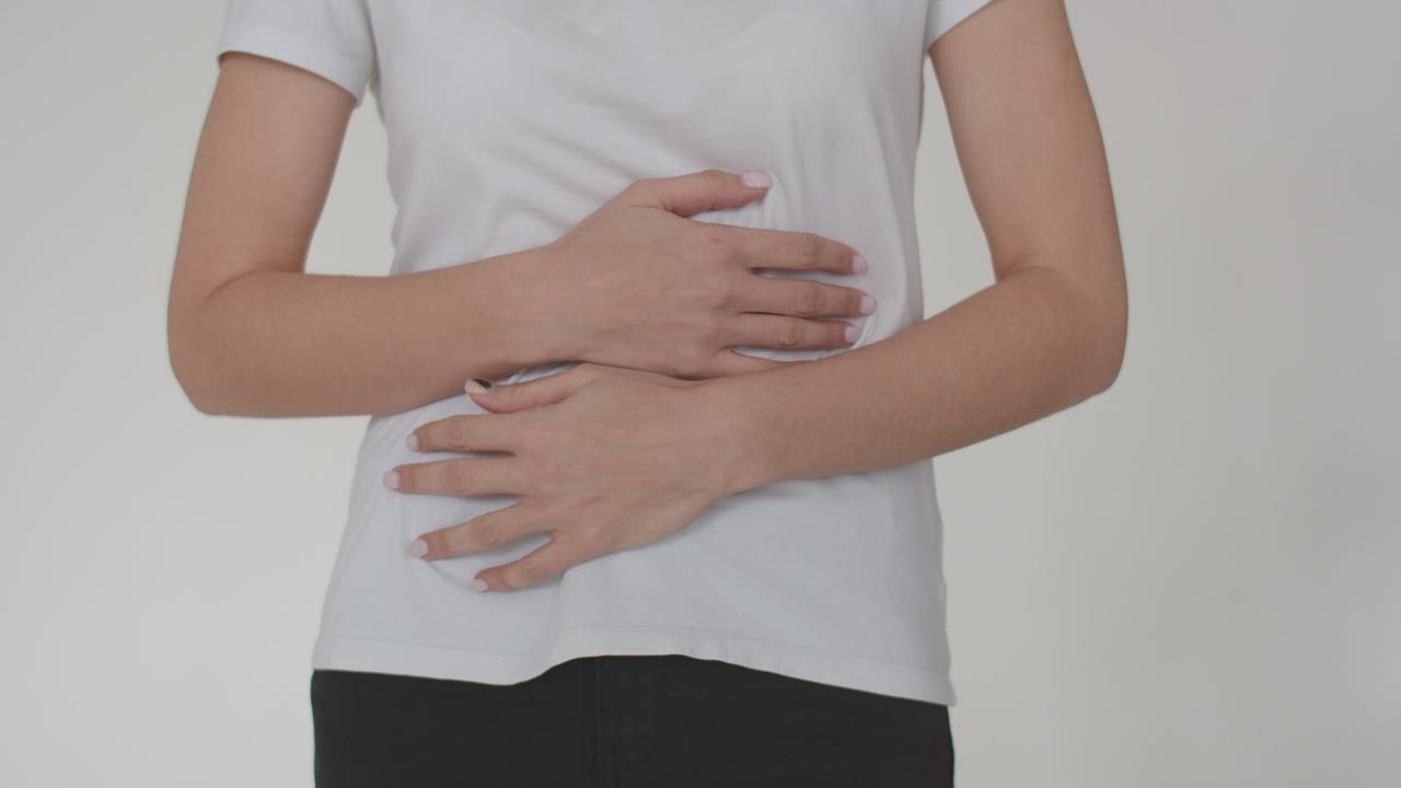 Person grabbing their stomach in pain - Free Stock Video
